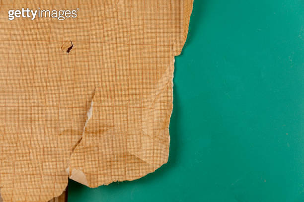 Ripped crumpled sheet of millimeter graph paper against a green ...
