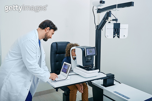 Optometrist using autorefractor determining required level of vision ...