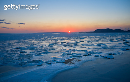 Aerial view of sunset over the frozen sea. Winter landscape on seashore ...