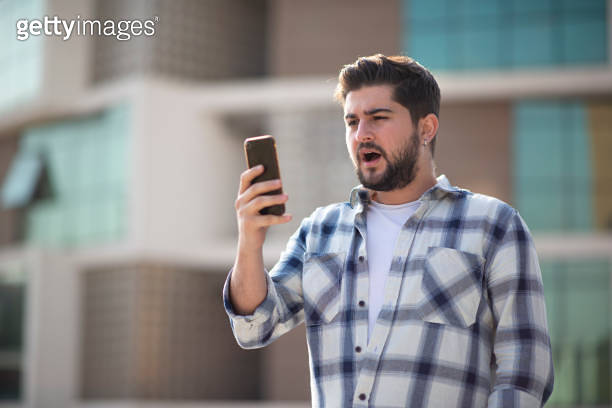 Upset man looking at his mobile phone 이미지 (1390683647) - 게티이미지뱅크