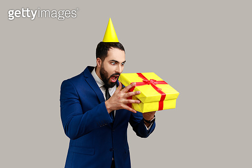 Man opening gift box and looking inside with shocked scared expression ...