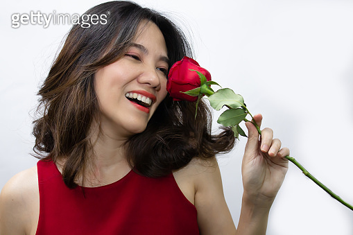 Close up Asian beautiful women are smelling red rose and smiling and ...