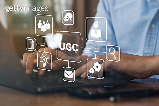 Businessman using a computer to "UGC" abbreviation and icon on laptop ...