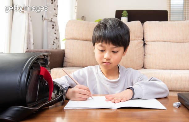 Japanese boy returning home from school and doing homework in the ...
