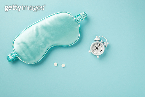 Top view photo of a big blue blindfold for sleep with a small alarm and ...