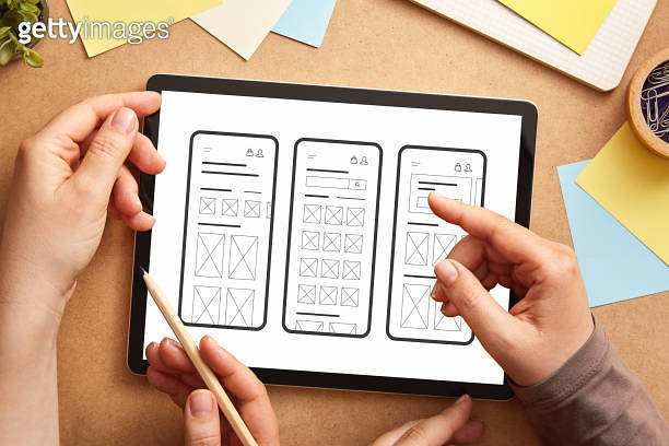 UX designers working on mobile app wireframes with a tablet (1383431112 ...