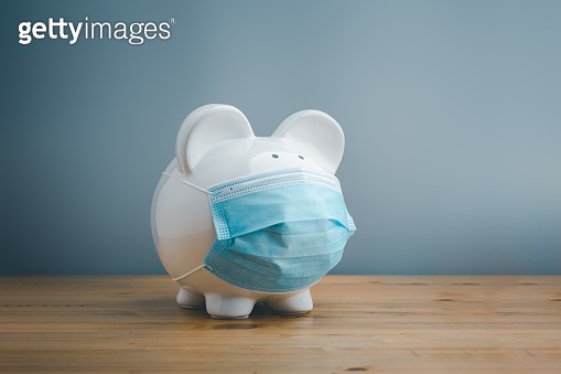 Piggy bank wearing surgical face mask. Global economy during ...