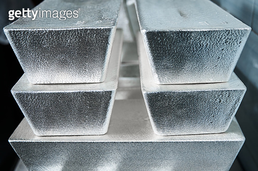 Stack of industrial silver ingots at bright light in storage ...