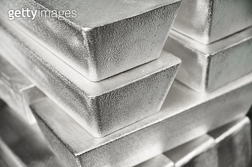Stack of industrial silver ingots at bright light in storage ...