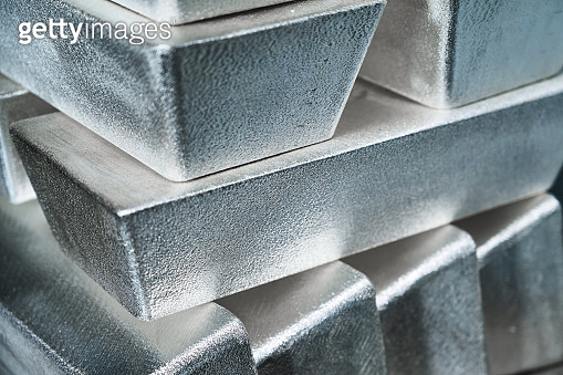 Stack of industrial silver ingots at bright light in storage ...