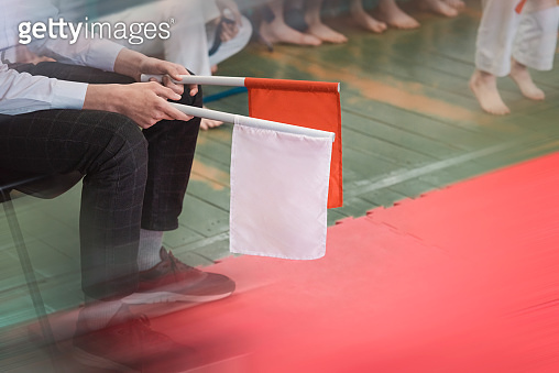 Karate referee with red and white flags at the competition. (1403882352 ...