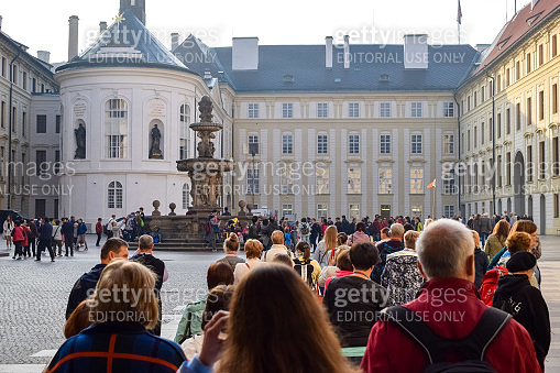 Crowd of tourists walk across the square with old buildings in Prague ...