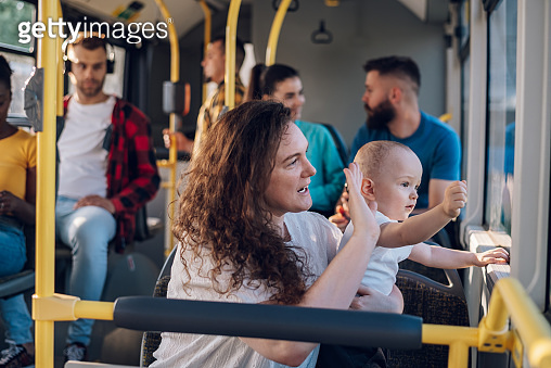 Mother and a baby riding in a bus in the city 이미지 (1414829696) - 게티이미지뱅크