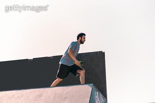 Sporty man training jumping over wall in skatepark 이미지 (1372503713 ...