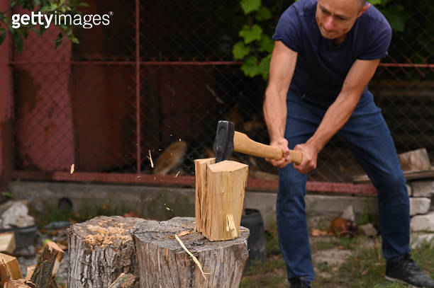 The log shatters with splinters. close-up. woodcutter is chopping wood ...