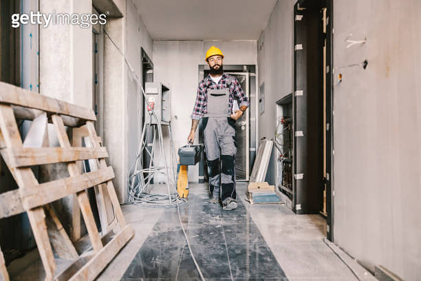 A worker in building in construction process carry toolbox and getting ...