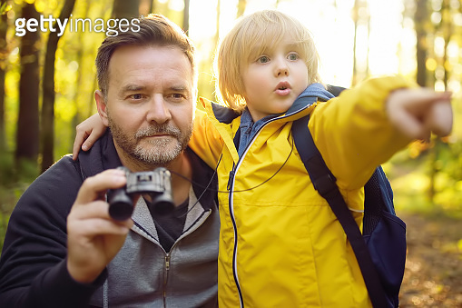School child and his father hiking together and exploring nature with ...