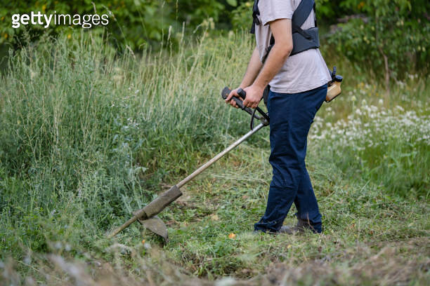 caucasian man farmer using string trimmer to cut grass brush cutter 이미지 ...