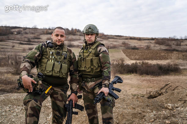 Two men front view portrait of soldiers in camouflage uniform armed ...