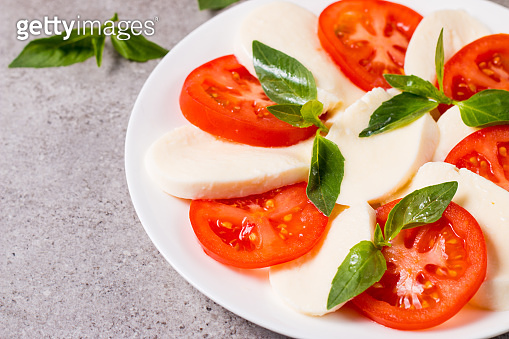 Close-up photo of caprese salad with ripe tomatoes, basil, buffalo ...