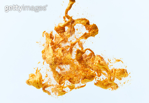 Golden paint splash curves in water on white. Acrylic metallic paint ...