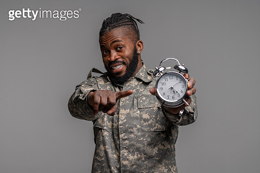 Soldier showing his mechanical wind-up twin bell alarm clock ...