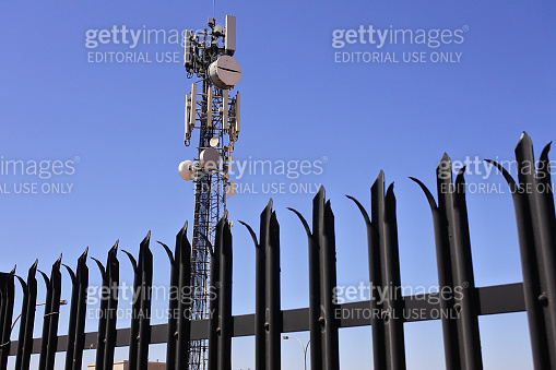 High protective sharp metal fence in front of a tall Telecommunication ...