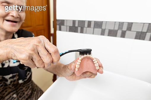 Asian senior woman showing a removable denture,old elderly brushing her ...
