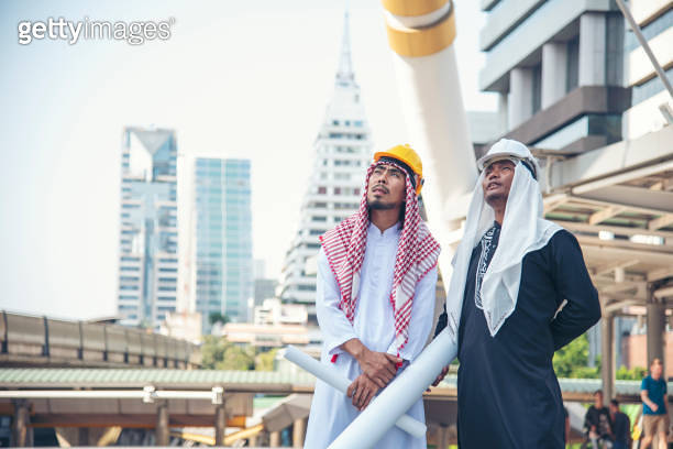 Arab civil engineer construction project hold blueprint, pointing at ...