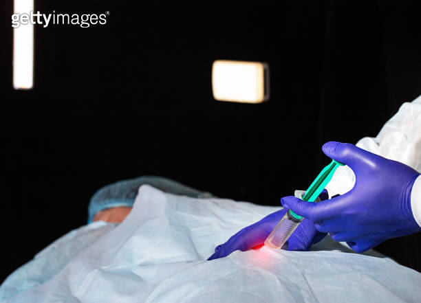 A neurosurgeon neurologist injects a medicine into a herniated disc to ...