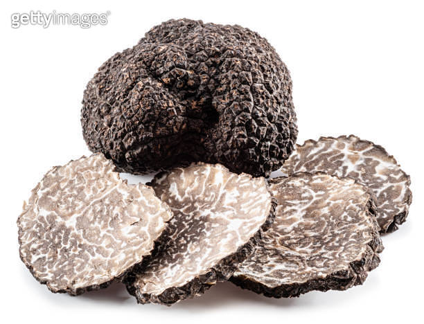 Black winter truffle and truffle slices on white background. The most ...