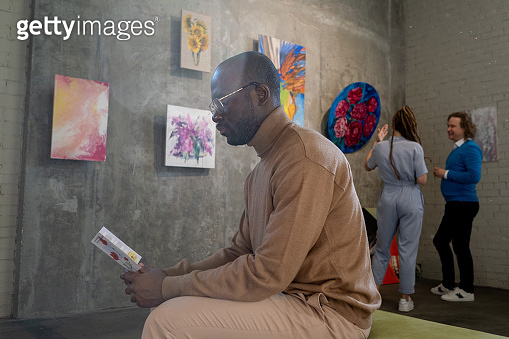 Man reading a brochure in art gallery 이미지 (1366948690) - 게티이미지뱅크
