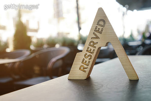 Reserved sign stands on wooden table of luxury street restaurant ...