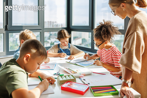 Teacher conducts a lesson, gives a lecture children during school work ...