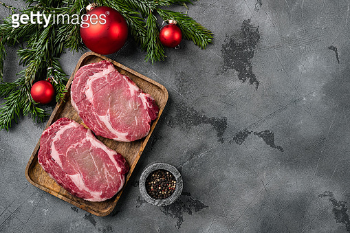 Fresh raw rib-eye steak with a Christmas tree, on gray stone table ...