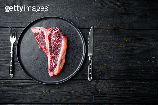 Sirloin beef meat marbled steak, T bone cut, on black wooden table ...