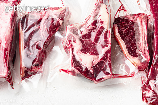 Raw beef meat in the vacuumed skin pack, tomahawk, t bone, club steak ...