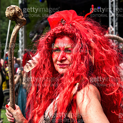 Older lady with tangled red hair and red face paint is dressed as a ...