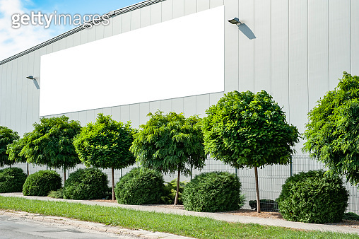 Blank white billboard for advertisement mounted on the wall of ...