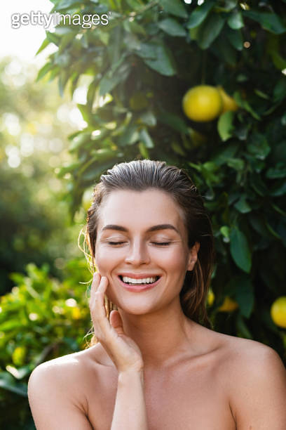 Portrait of beautiful woman with smooth skin against lemon trees 이미지 ...