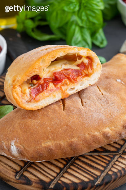Traditional closed Italian calzone pizza with tomato sauce, mozzarella ...