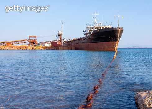 Large cargo ship - bulk carrier - is loaded in the Aegean sea on the ...