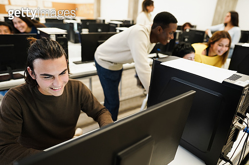 Young multiracial students using computers during business class at ...