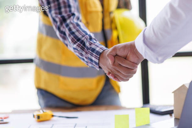 Architect contractor shaking hands with client after seal a deal to ...