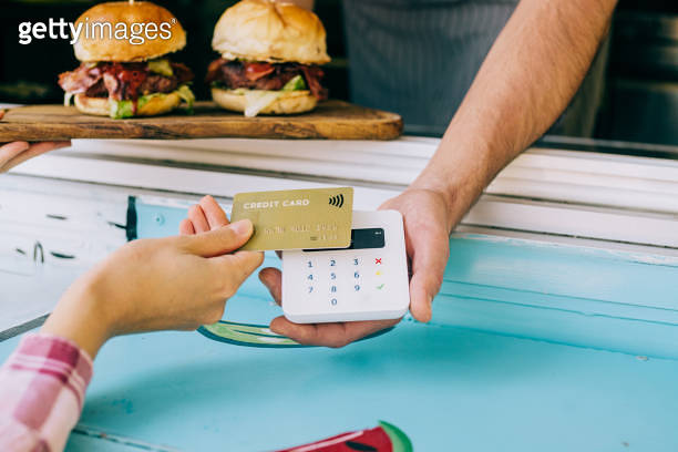 Woman buying burgers from food van and using credit card. 이미지 ...