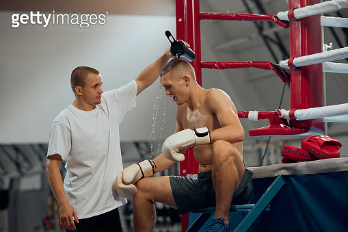 Professional boxer training with personal coach, trainer at boxing ring ...