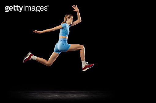 Young sportive girl, long jumper in sports blue uniform performs triple ...