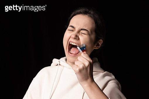 Half-legth portrait of young emotional girl rips three colors duct tape ...