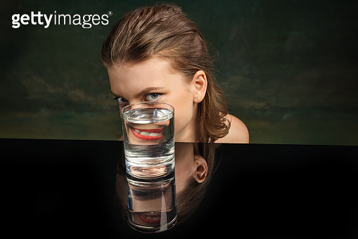 Modern art photography. Funny weird girl's face through glass of water ...