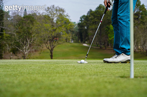 Golfer playing golf in the evening golf course, on sun set evening time ...